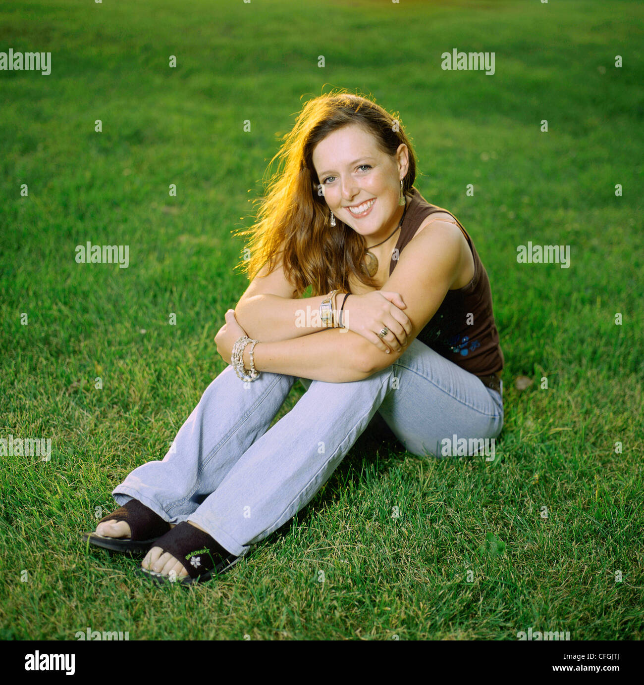 Young Woman sitting on Grass Stock Photo - Alamy
