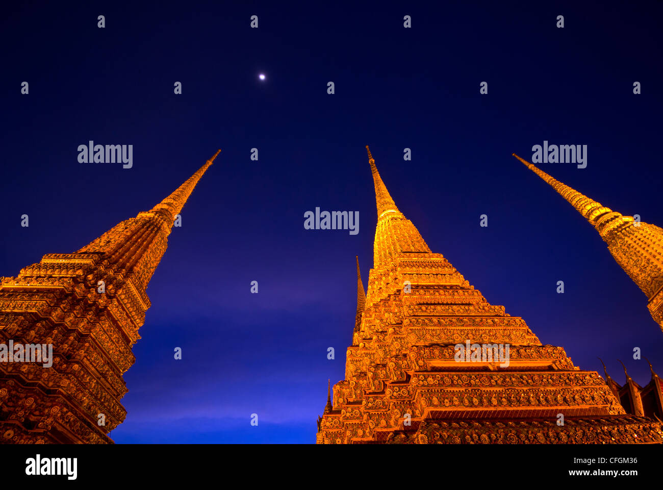 Moonrise over the prang of the Phra Maha Chedi rising into night sky ...