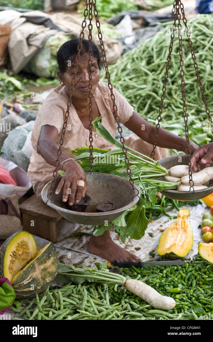 Lady weighing vegetables in market Stock Photo - Alamy