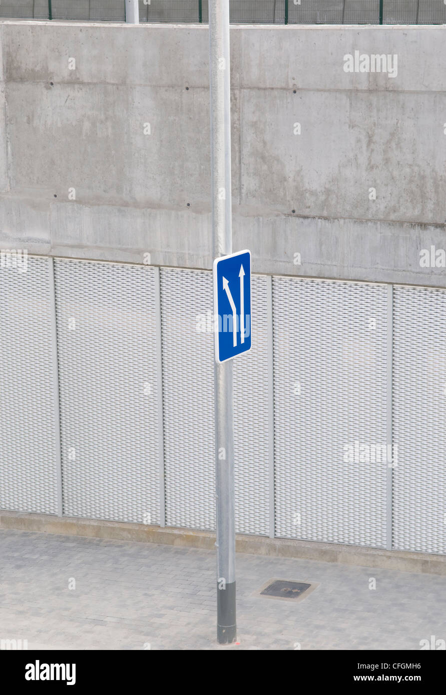 Blue road sign with white arrows indicating directions for traffic in ...