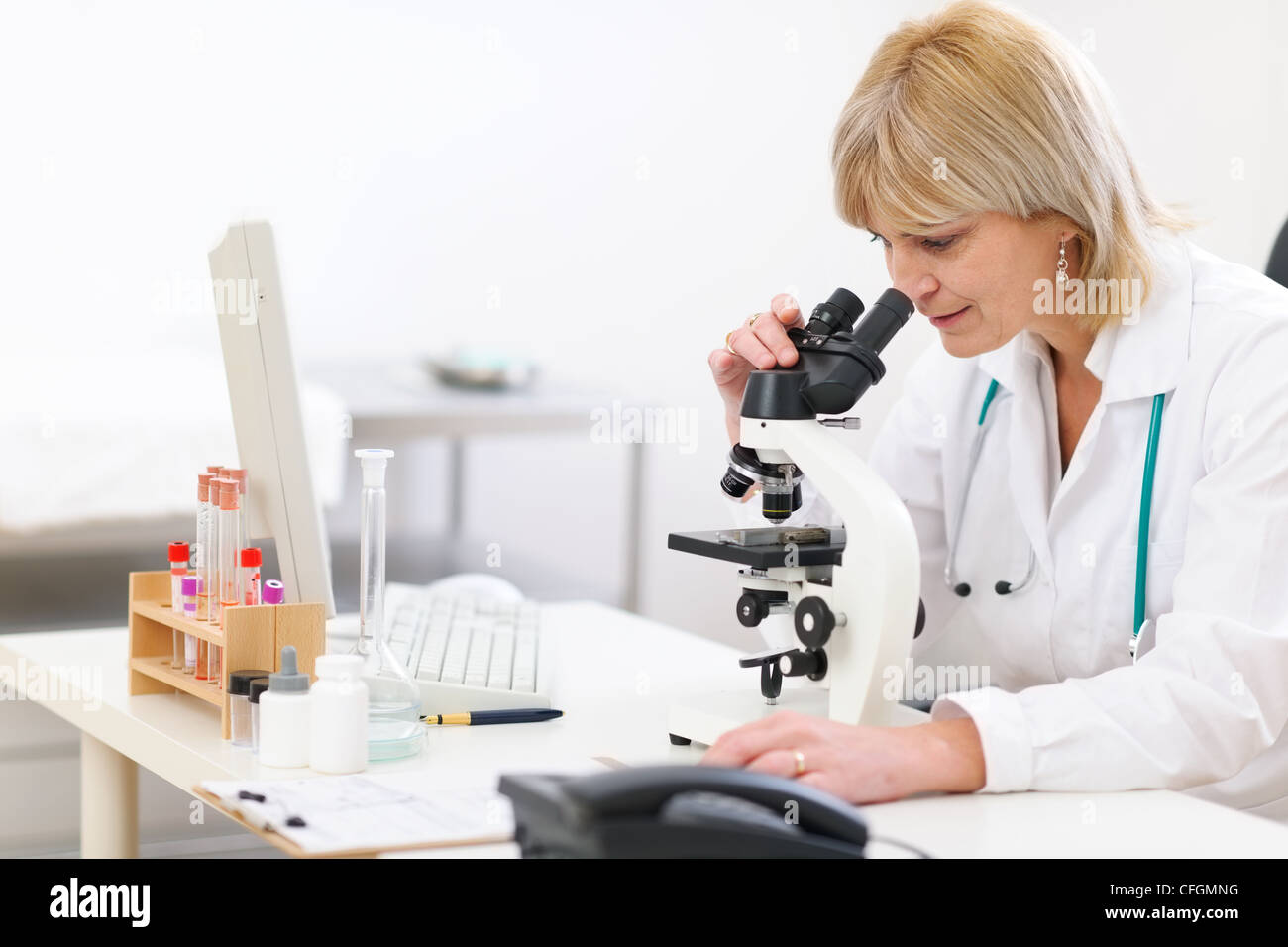 Senior female doctor looking in microscope at laboratory Stock Photo ...