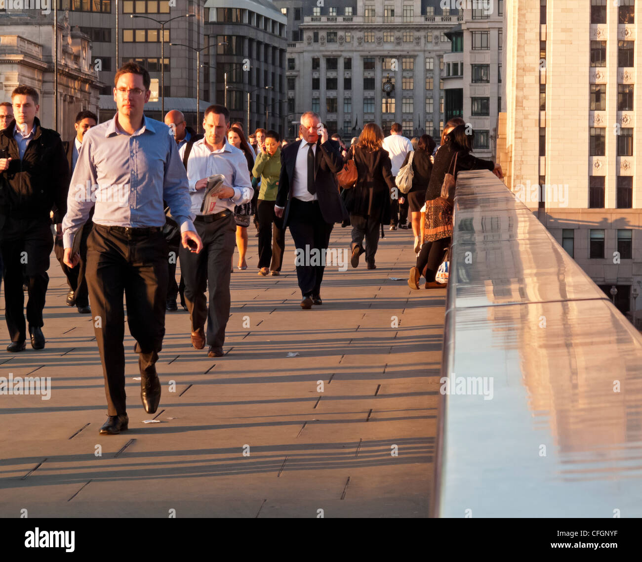 Commuters walking across London Bridge in the City of London financial ...