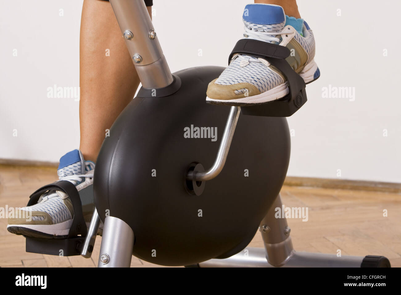 Detail image of legs using a fitness bicycle in a gym Stock Photo - Alamy