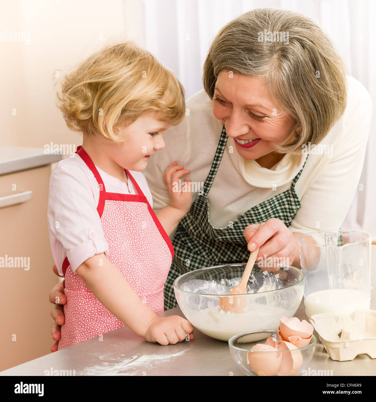 Child girl and grandmother baking cake stir dough Stock Photo - Alamy