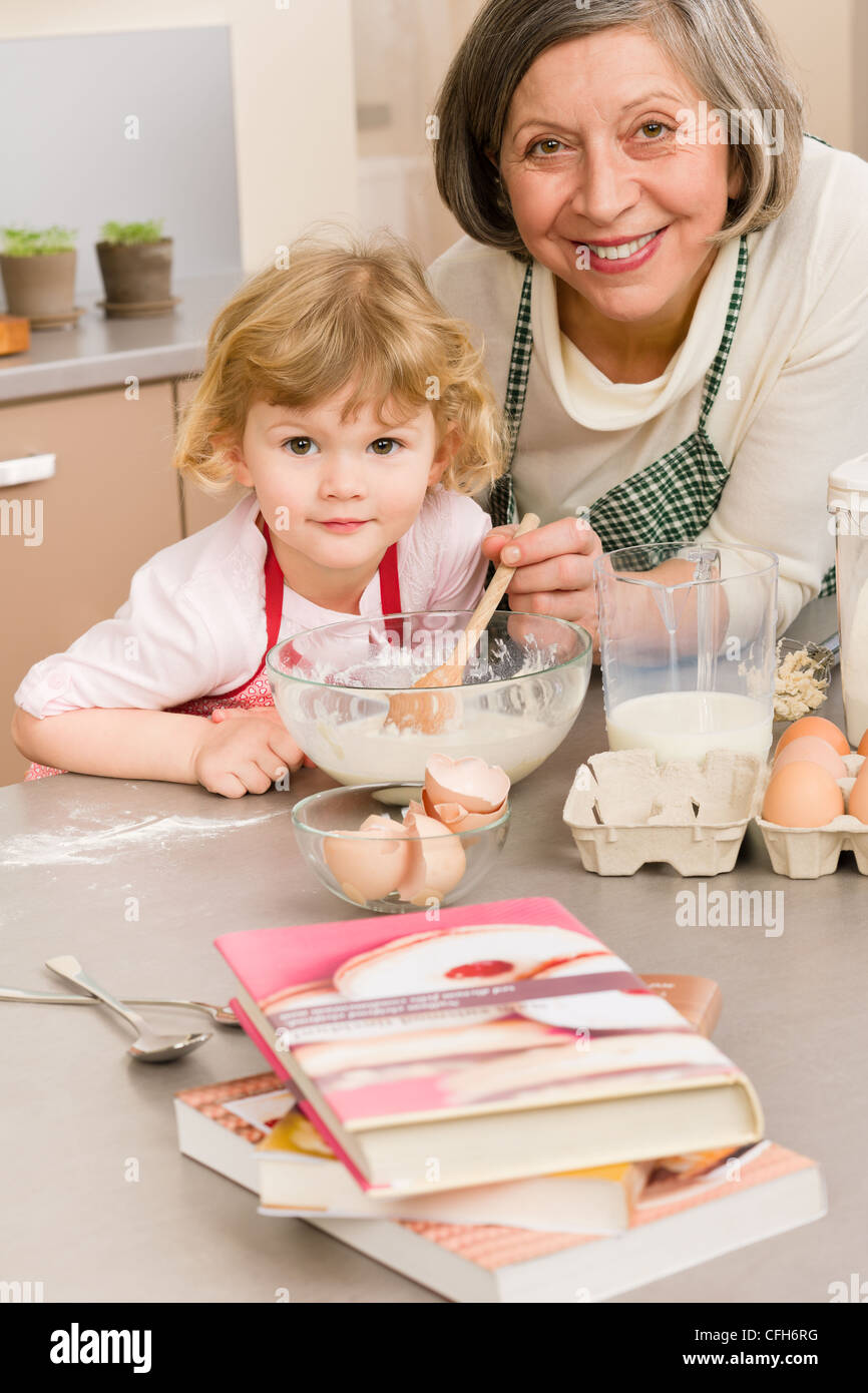 Child girl and grandmother baking cake stir dough Stock Photo - Alamy