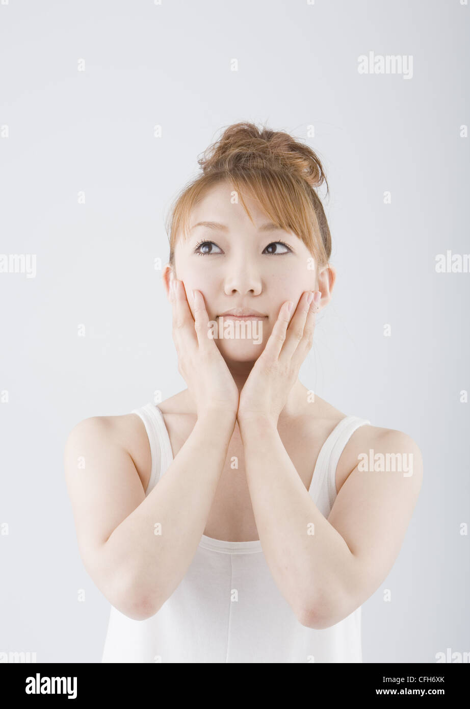 Young woman with hands on cheeks Stock Photo - Alamy