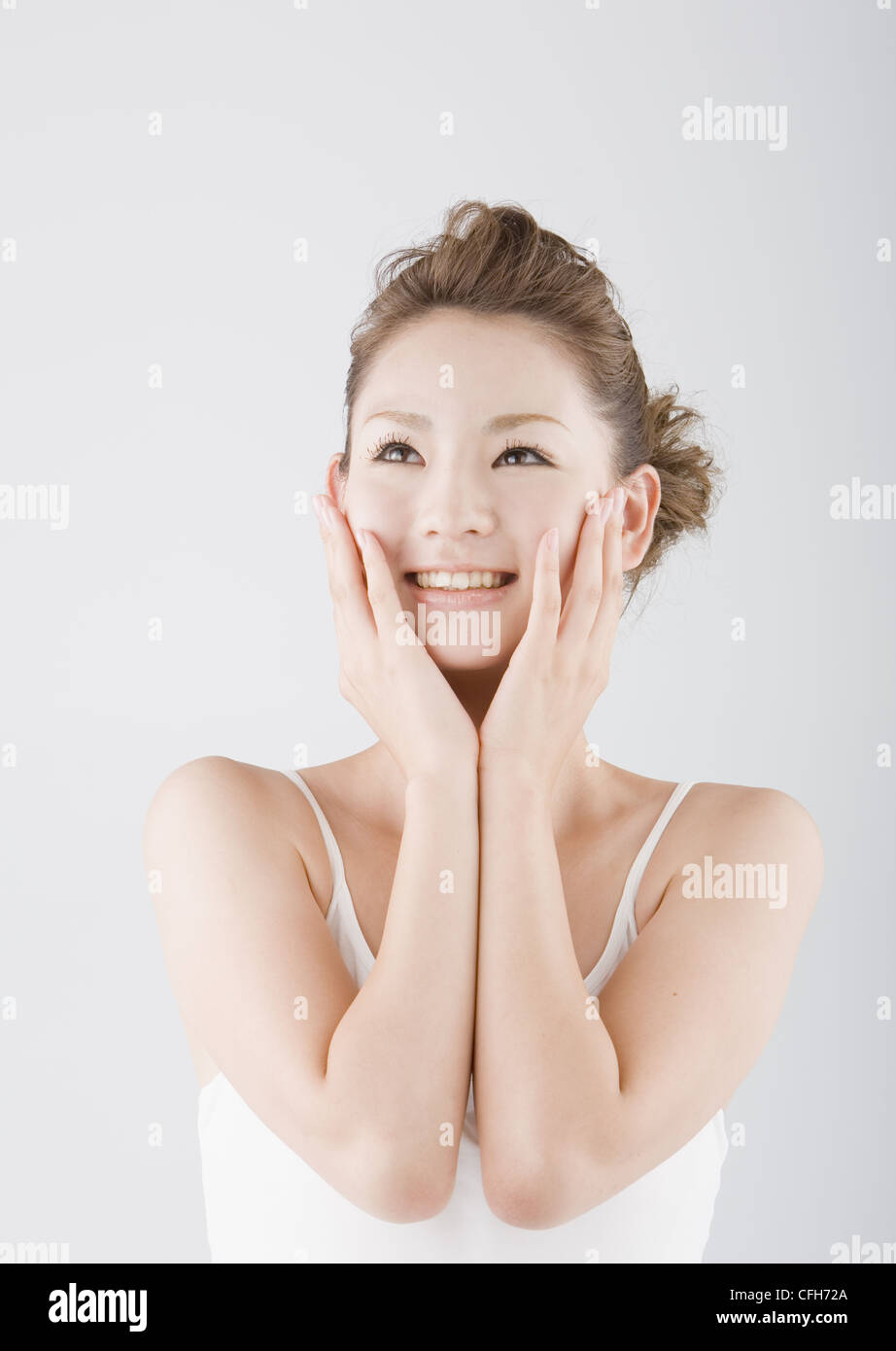 Young woman with hands on cheeks Stock Photo - Alamy