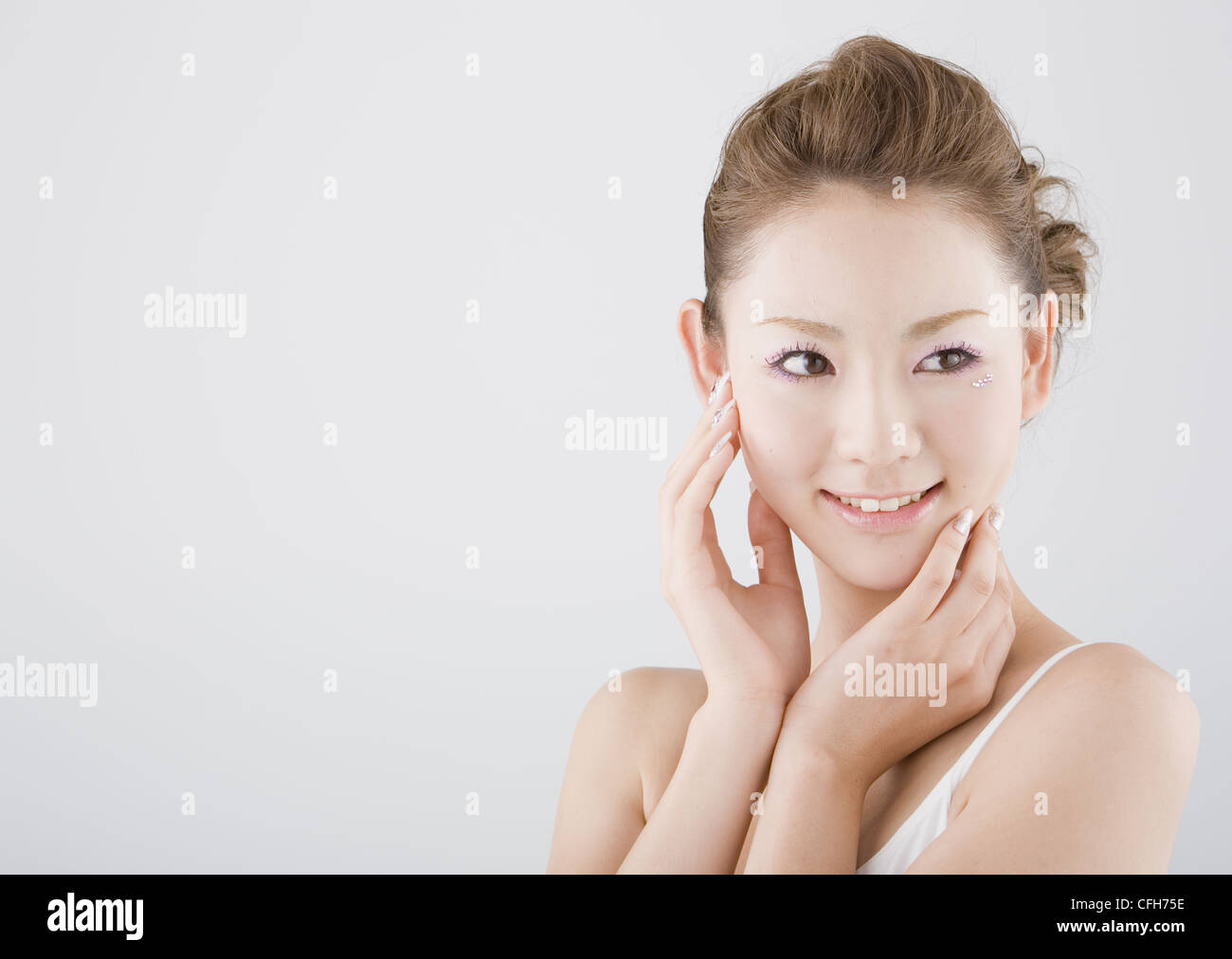 Young woman with hands on cheeks Stock Photo - Alamy