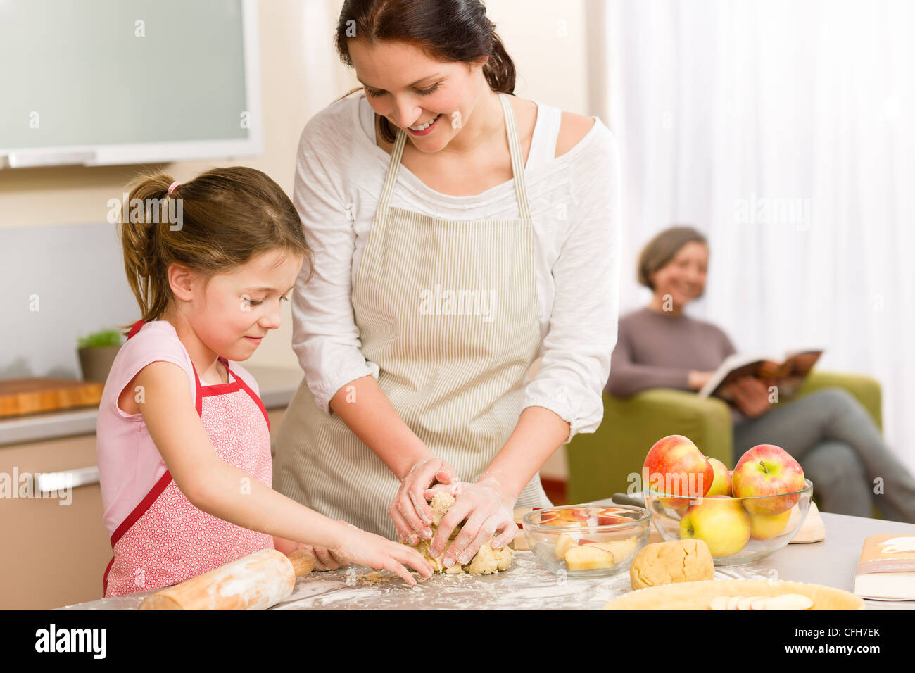 Mother and daughter making apple pie together grandmother check recipe ...