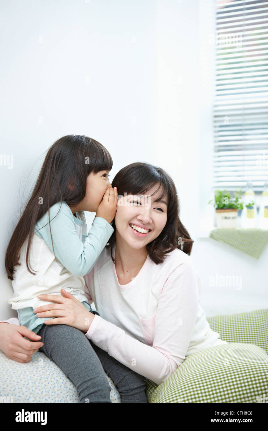 The girl whispering in woman's ear Stock Photo - Alamy