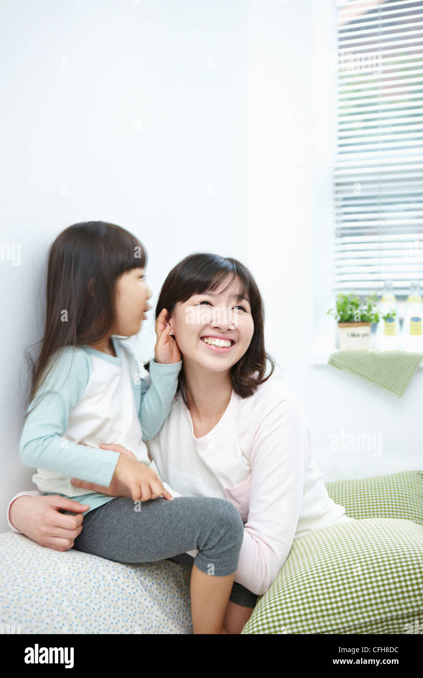 The girl whispering in woman's ear Stock Photo - Alamy