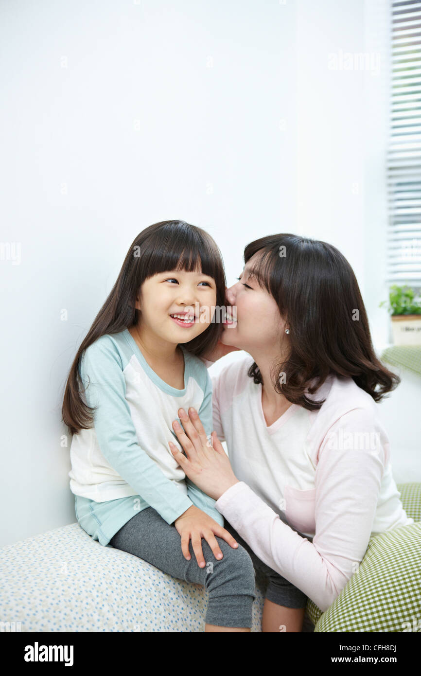 The woman whispering in girl's ear Stock Photo - Alamy