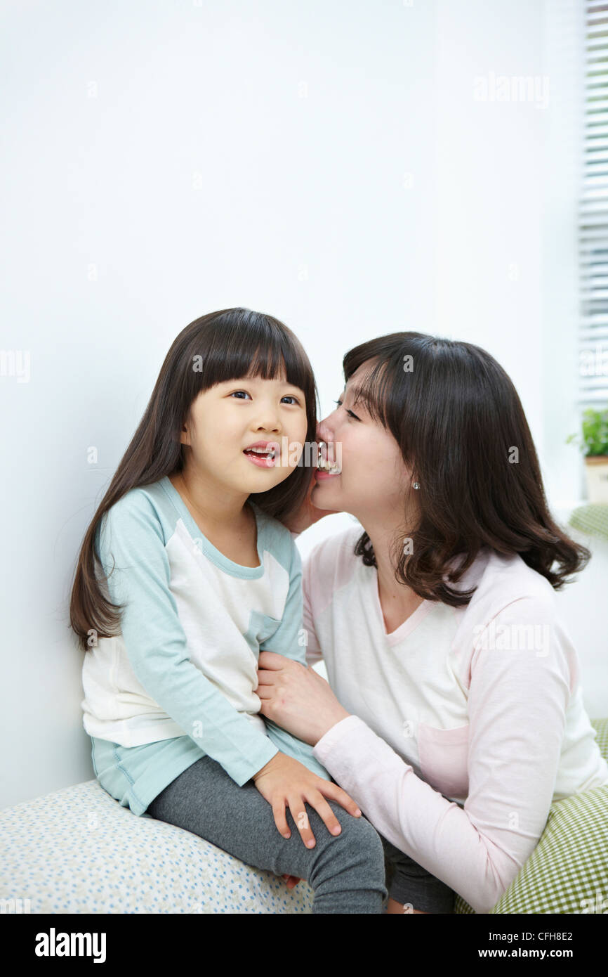 The woman whispering in girl's ear Stock Photo - Alamy