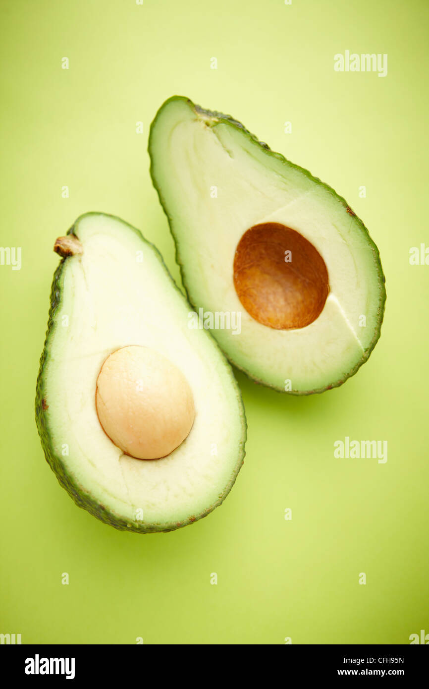 The avocado in half with the green background Stock Photo - Alamy