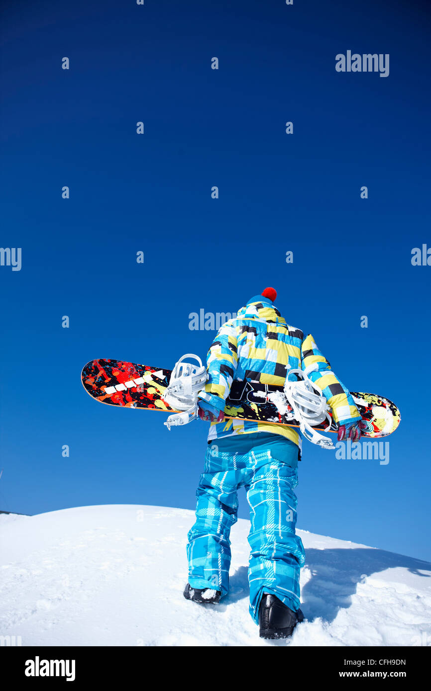 The man wearing snowboarding wear with the snowboard Stock Photo - Alamy