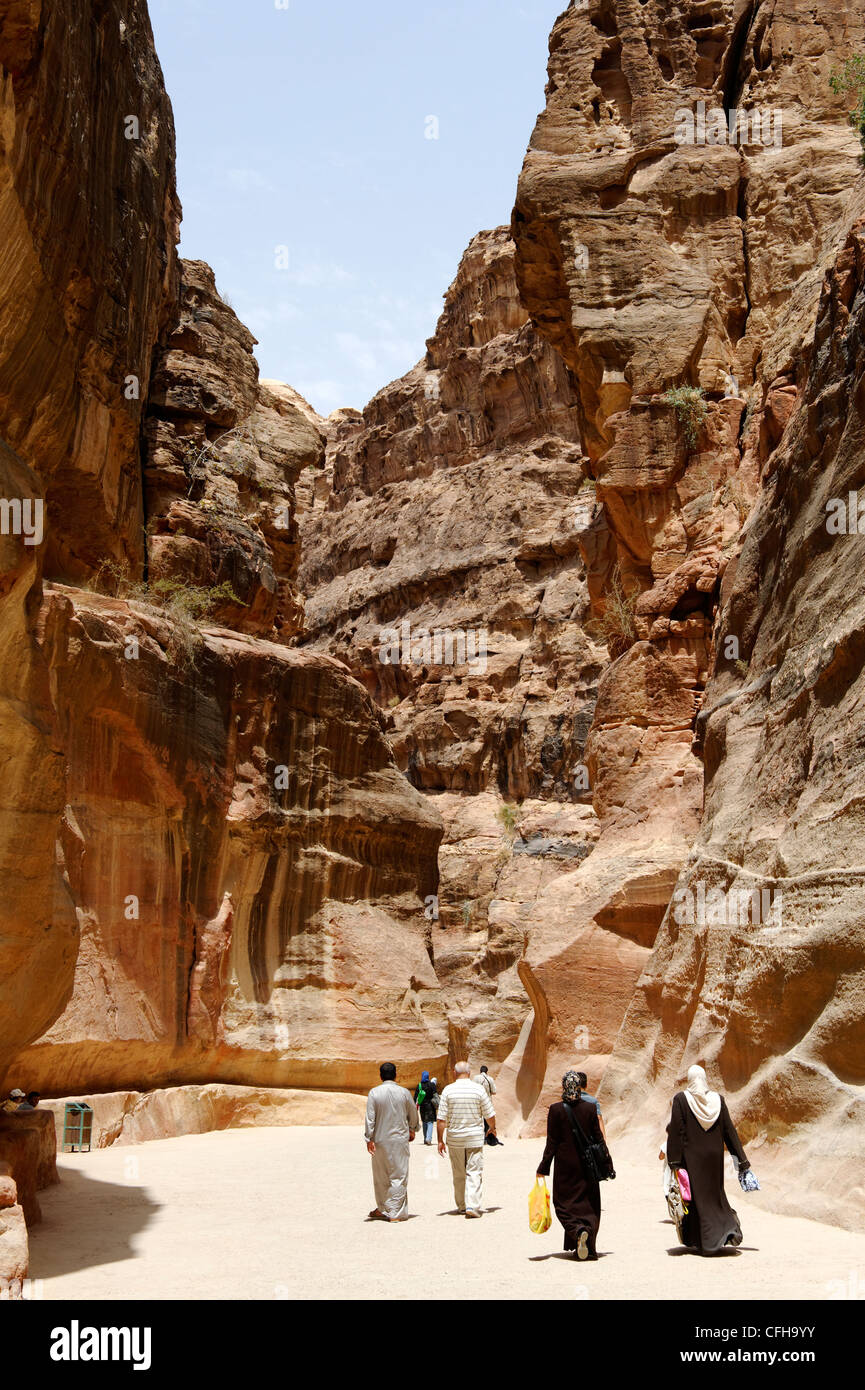 Petra. Jordan. View of tourists walking through the narrow ravine known ...