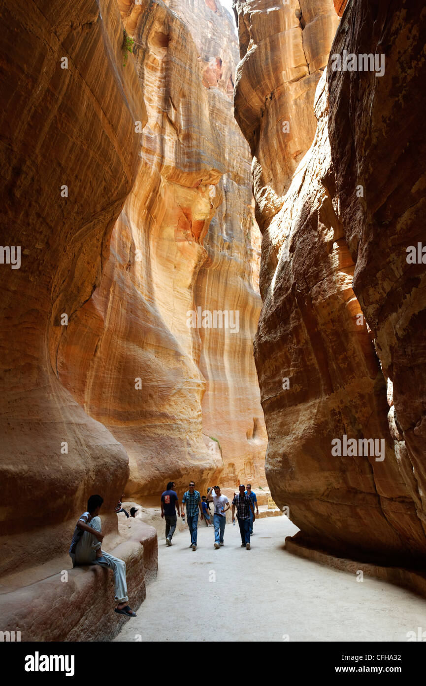 Petra. Jordan. View of tourists walking through the narrow ravine known ...