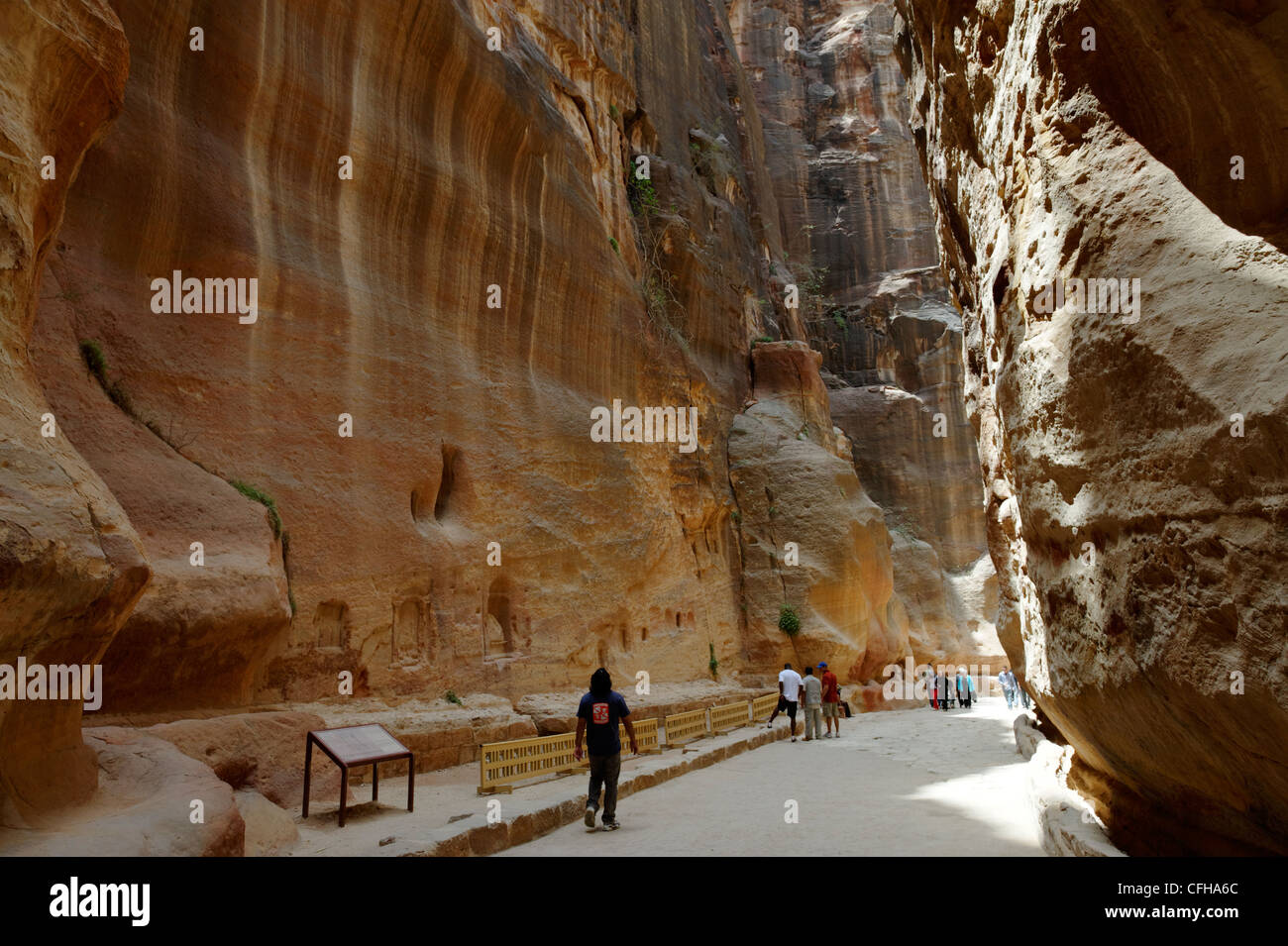 Petra. Jordan. View of tourists walking through the narrow ravine known ...