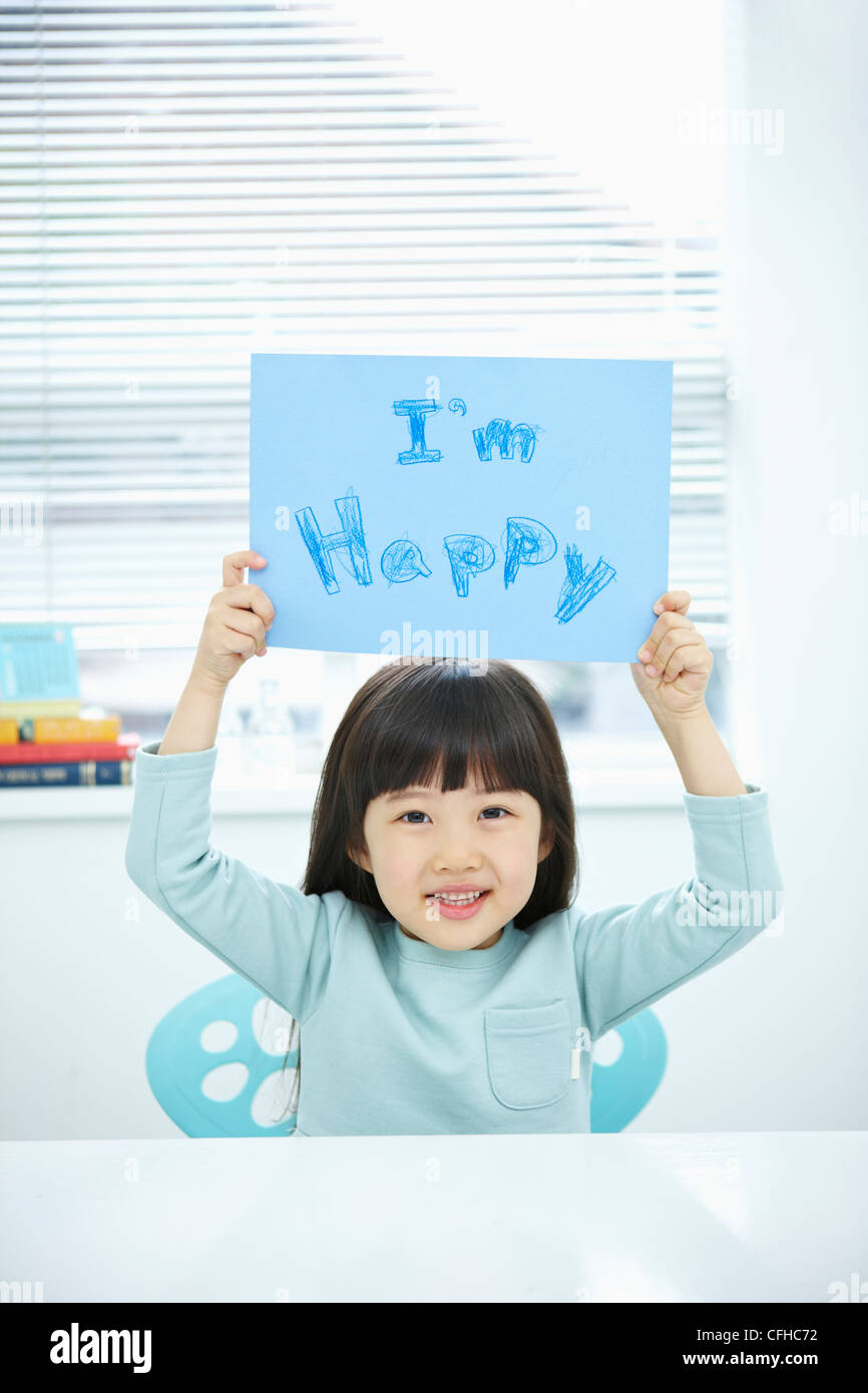 A girl holding up blue paper with 'I'm happy' Stock Photo - Alamy