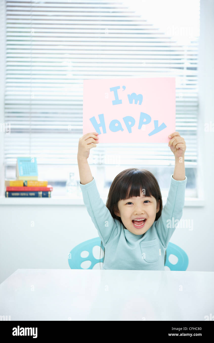 A girl holding up pink paper with 'I'm happy' Stock Photo - Alamy