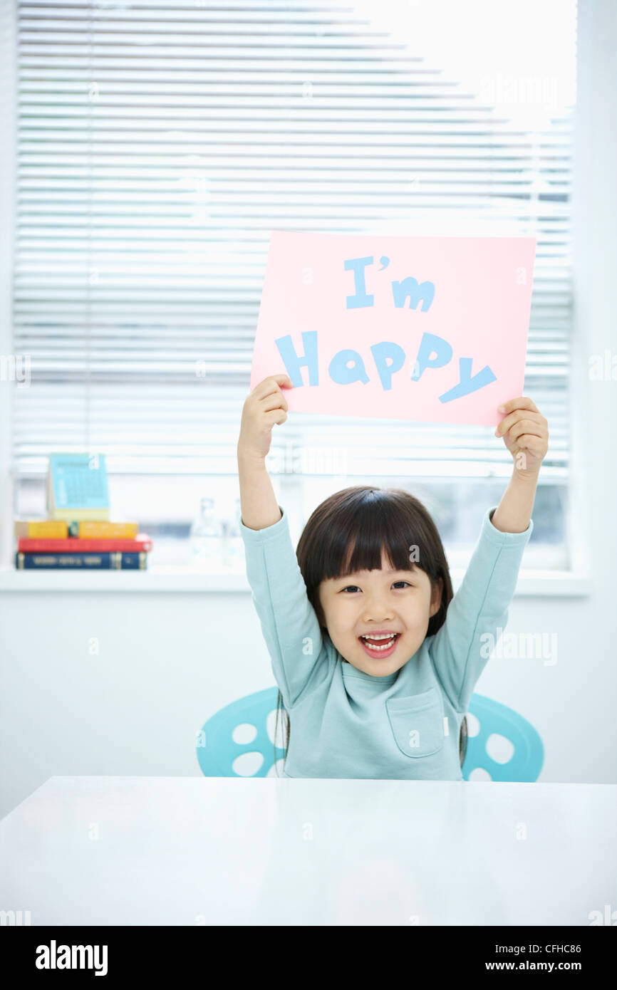 A girl holding up pink paper with 'I'm happy' Stock Photo - Alamy