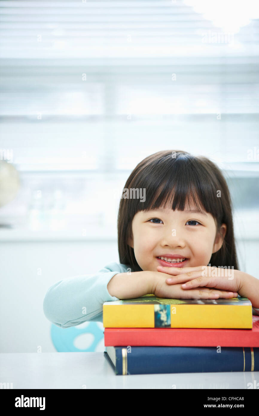 A girl having her hands on the pile of books Stock Photo - Alamy