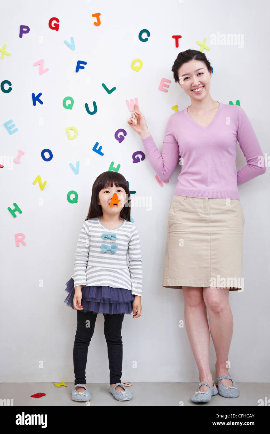 A woman and girl with alphabet blocks on the wall Stock Photo - Alamy