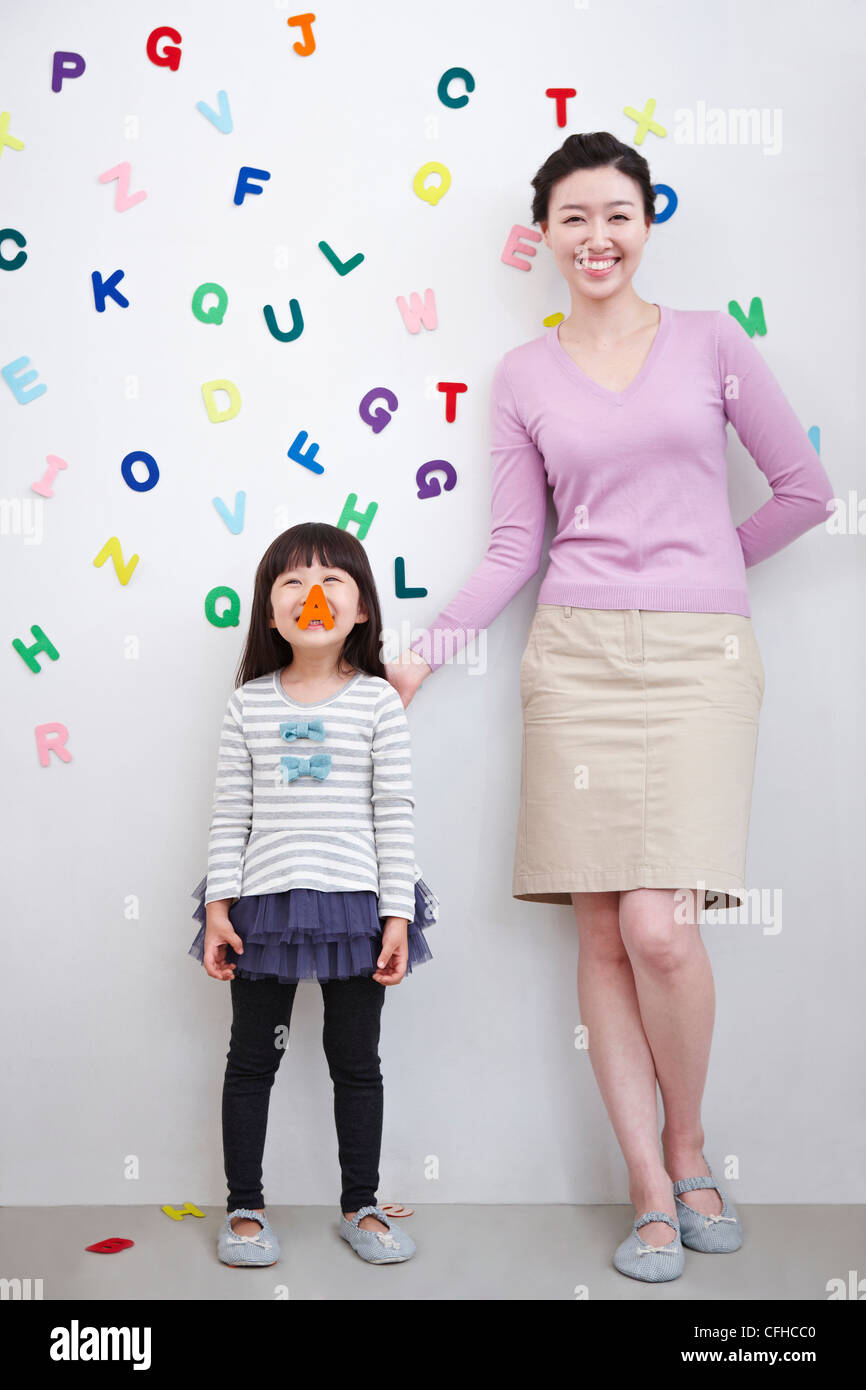 A woman and girl with alphabet blocks on the wall Stock Photo - Alamy