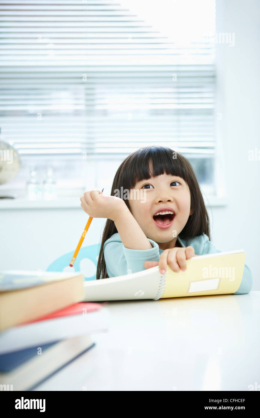 A smiling girl holding a notebook and pencil Stock Photo - Alamy