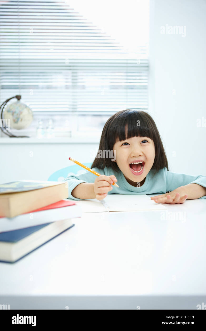 A smiling girl holding a notebook and pencil Stock Photo - Alamy