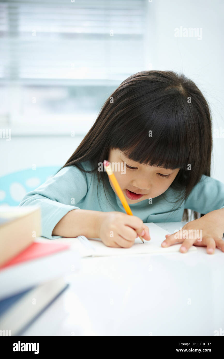 A girl writing on a notebook with a pencil Stock Photo - Alamy