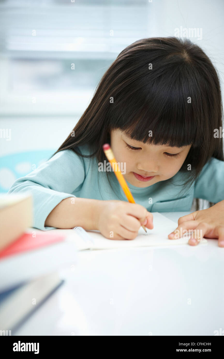 A girl writing on a notebook with a pencil Stock Photo - Alamy