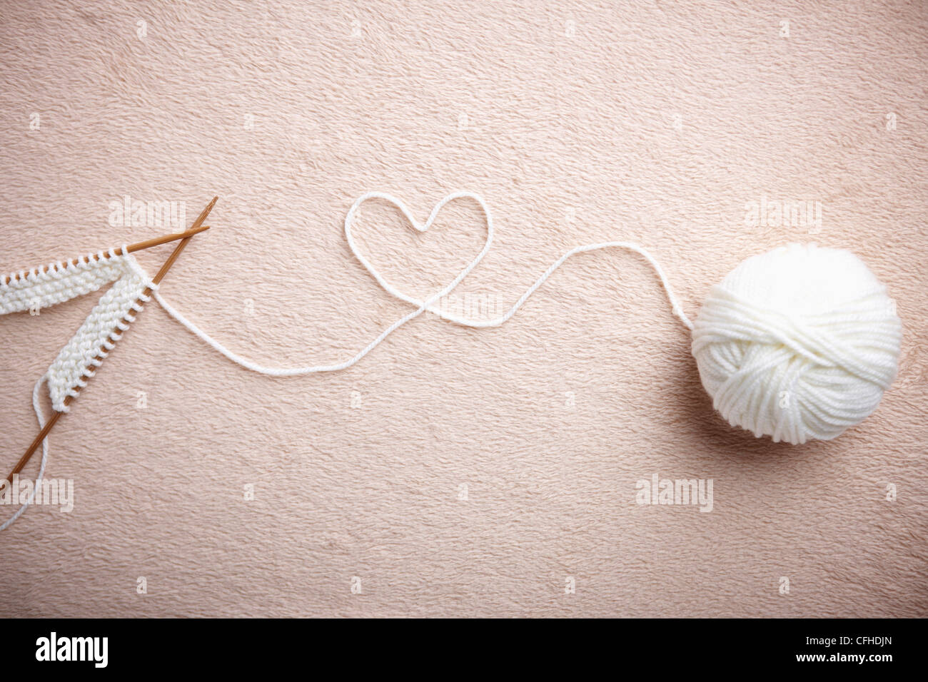 A ball of white wool and knitting needles making the heart Stock Photo ...