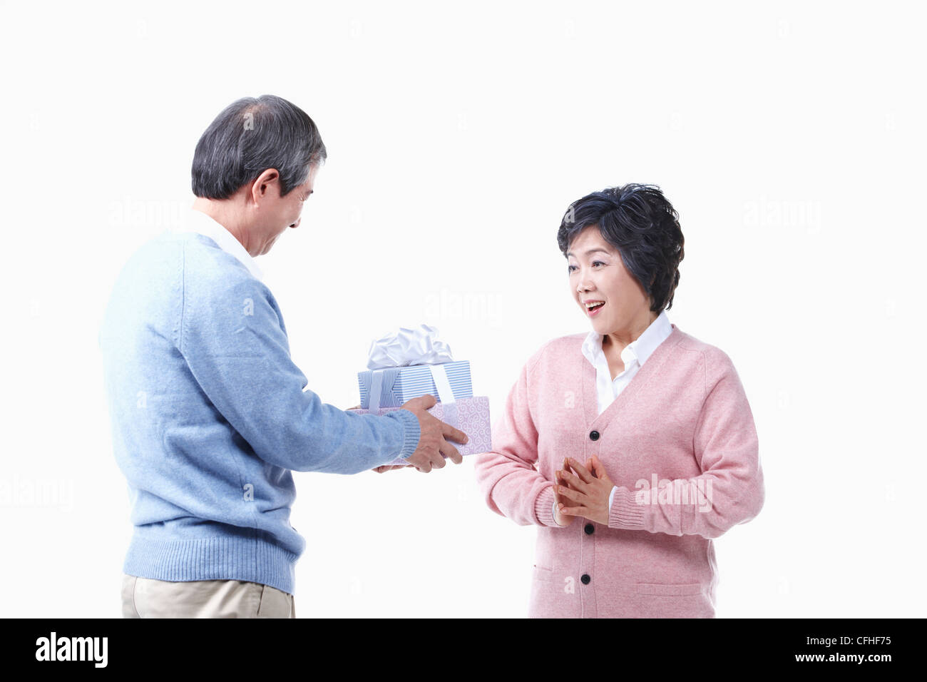 An elderly man giving the gift for an elderly woman Stock Photo - Alamy