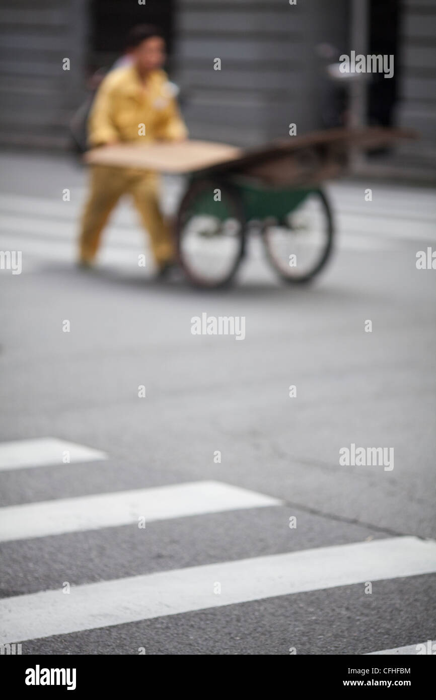 A man pushing a cart through the street in Shanghai Stock Photo - Alamy