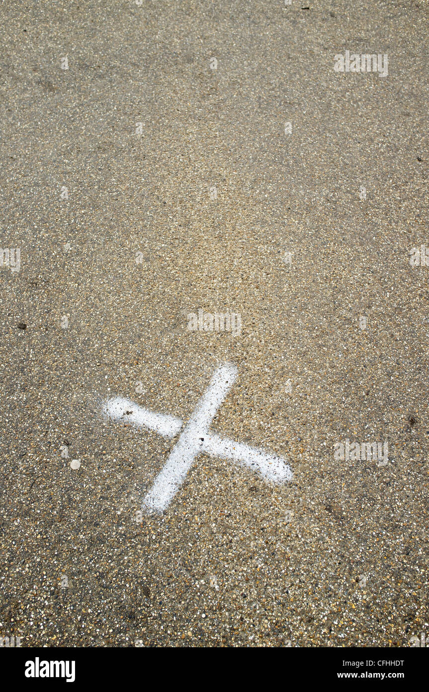 A white cross spray painted on the ground Stock Photo - Alamy