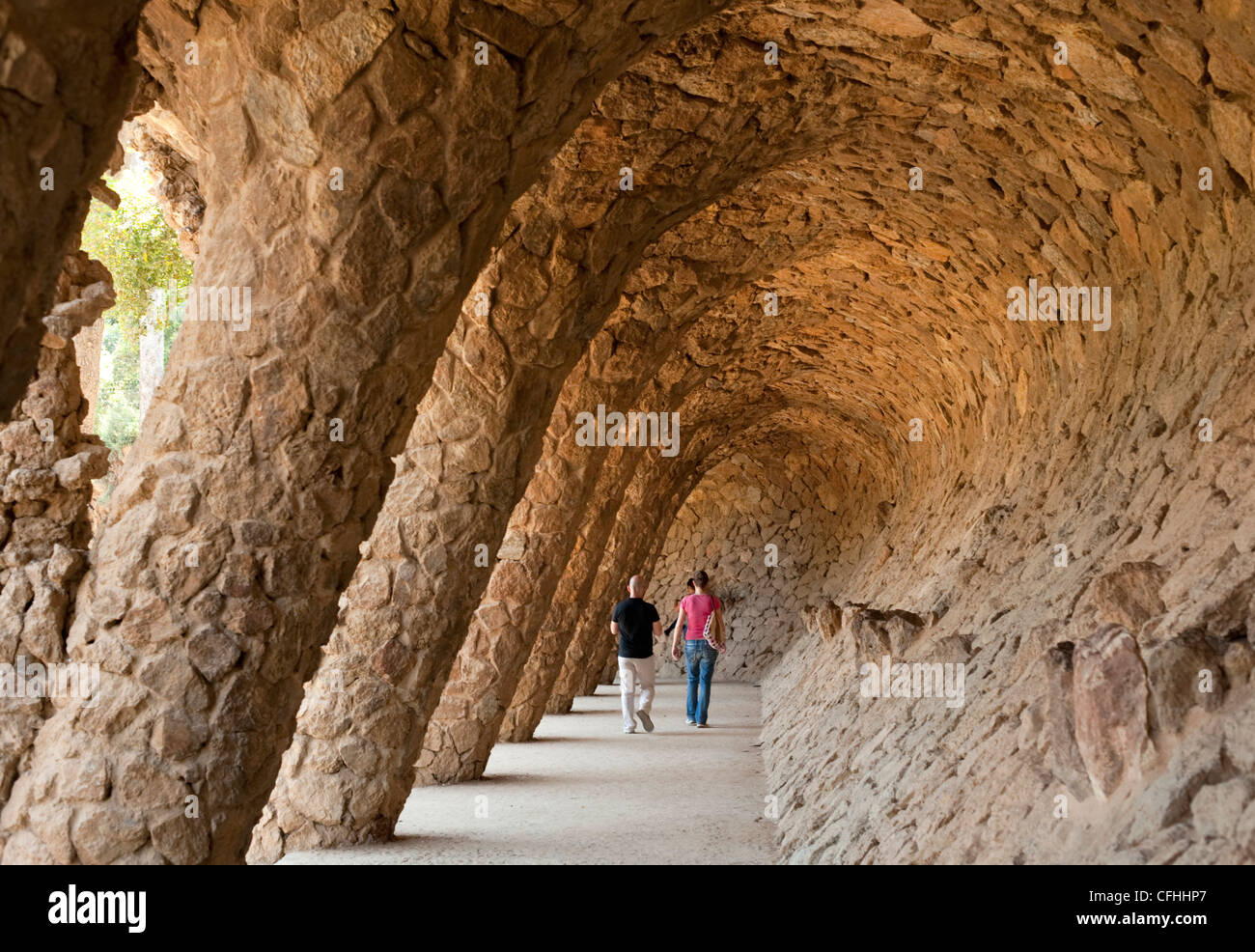 A pair of tourists walk below the arched sculpted terraced stone ...