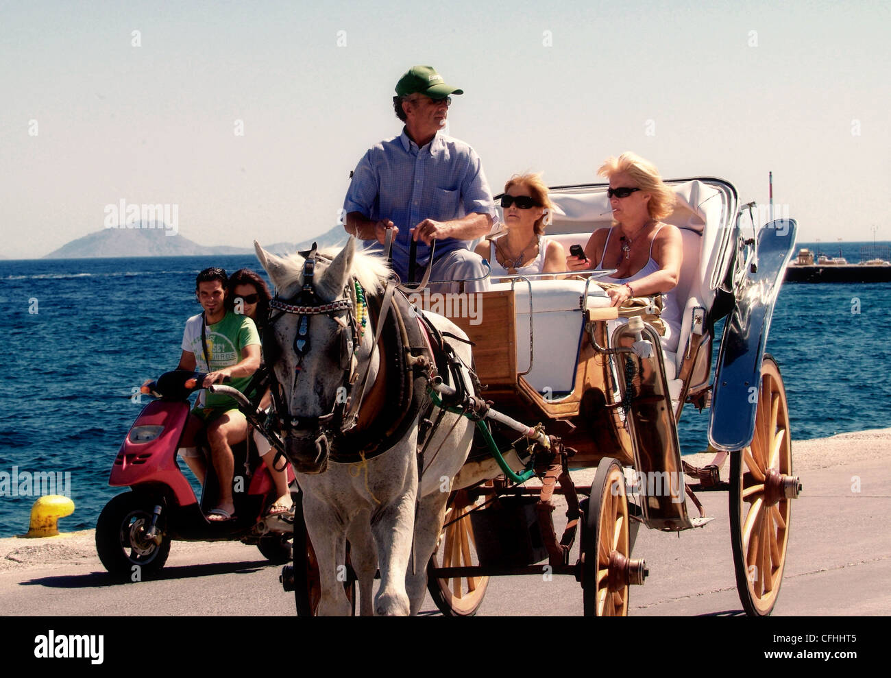 GREECE Saronic Gulf Island of Spetses old town. Couple on moped girls ...