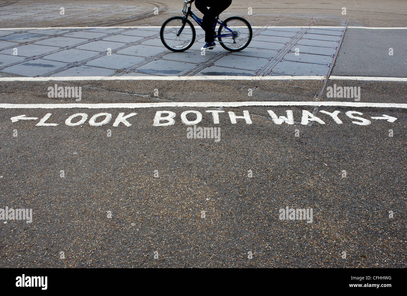 A cyclist passing a sign painted on the ground Stock Photo - Alamy