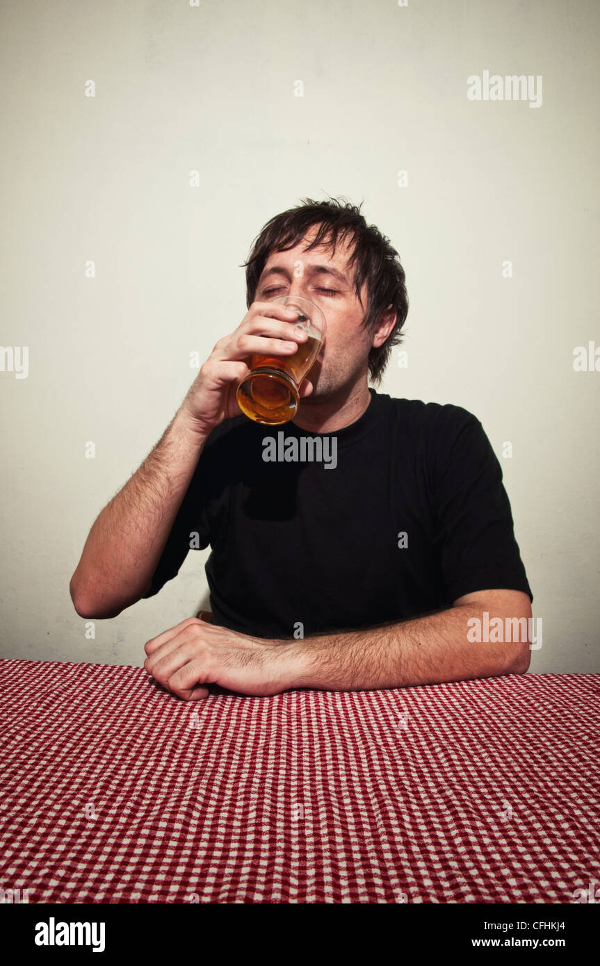 Drunk man at the pub table with a glass of cold, light beer Stock Photo ...