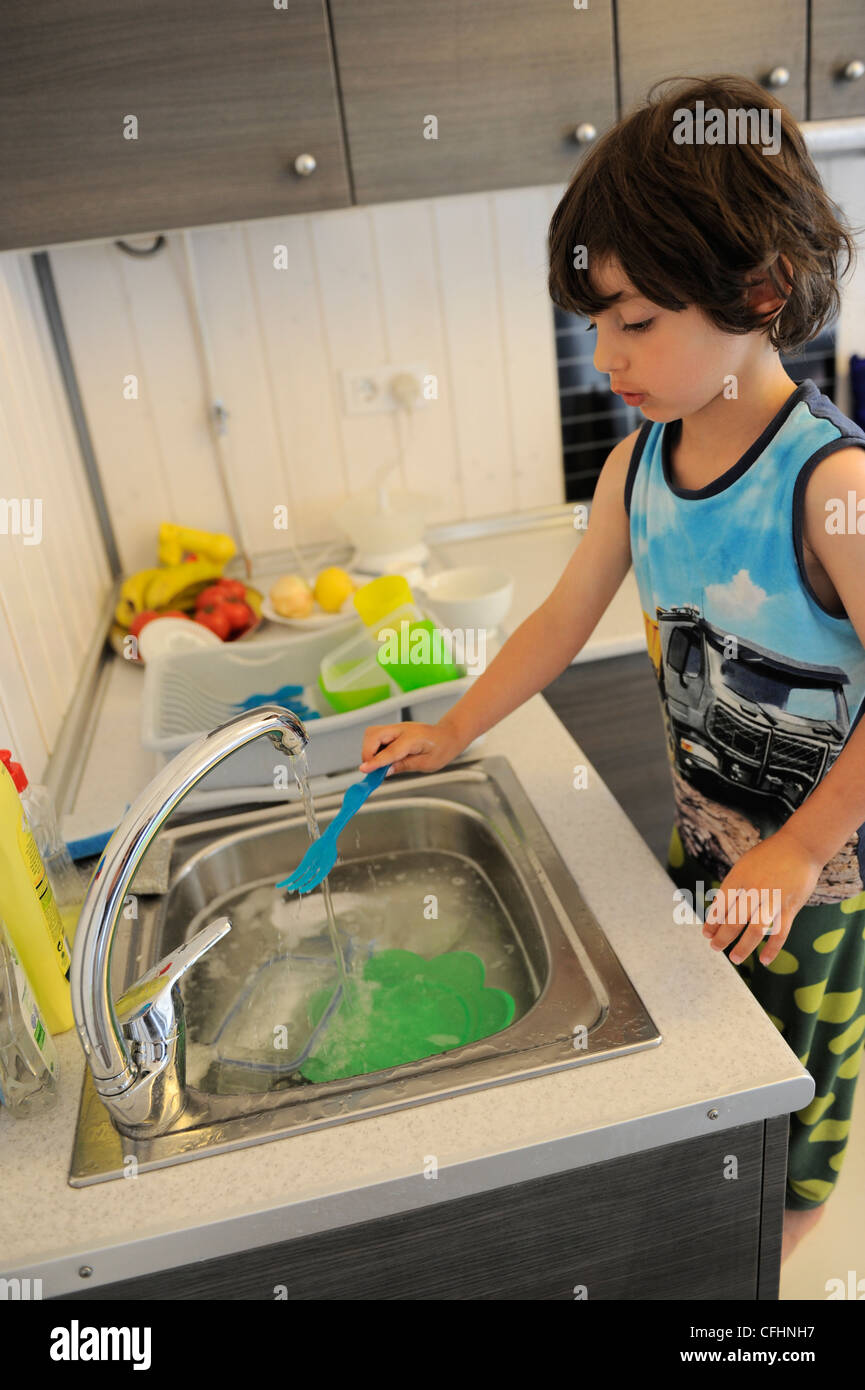 Boy washing plates hi-res stock photography and images - Alamy
