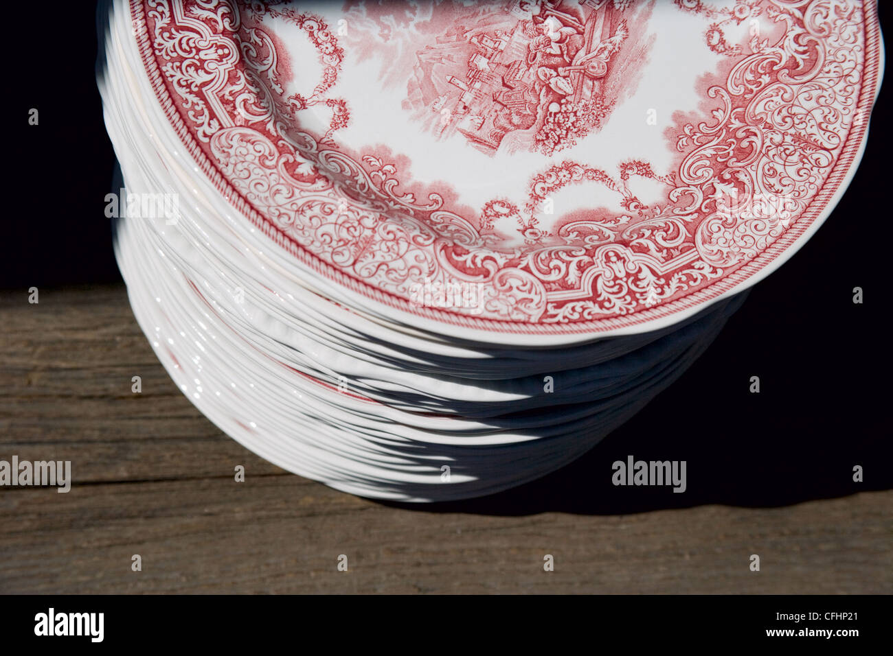 A stack of china plates on an old wooden table Stock Photo - Alamy