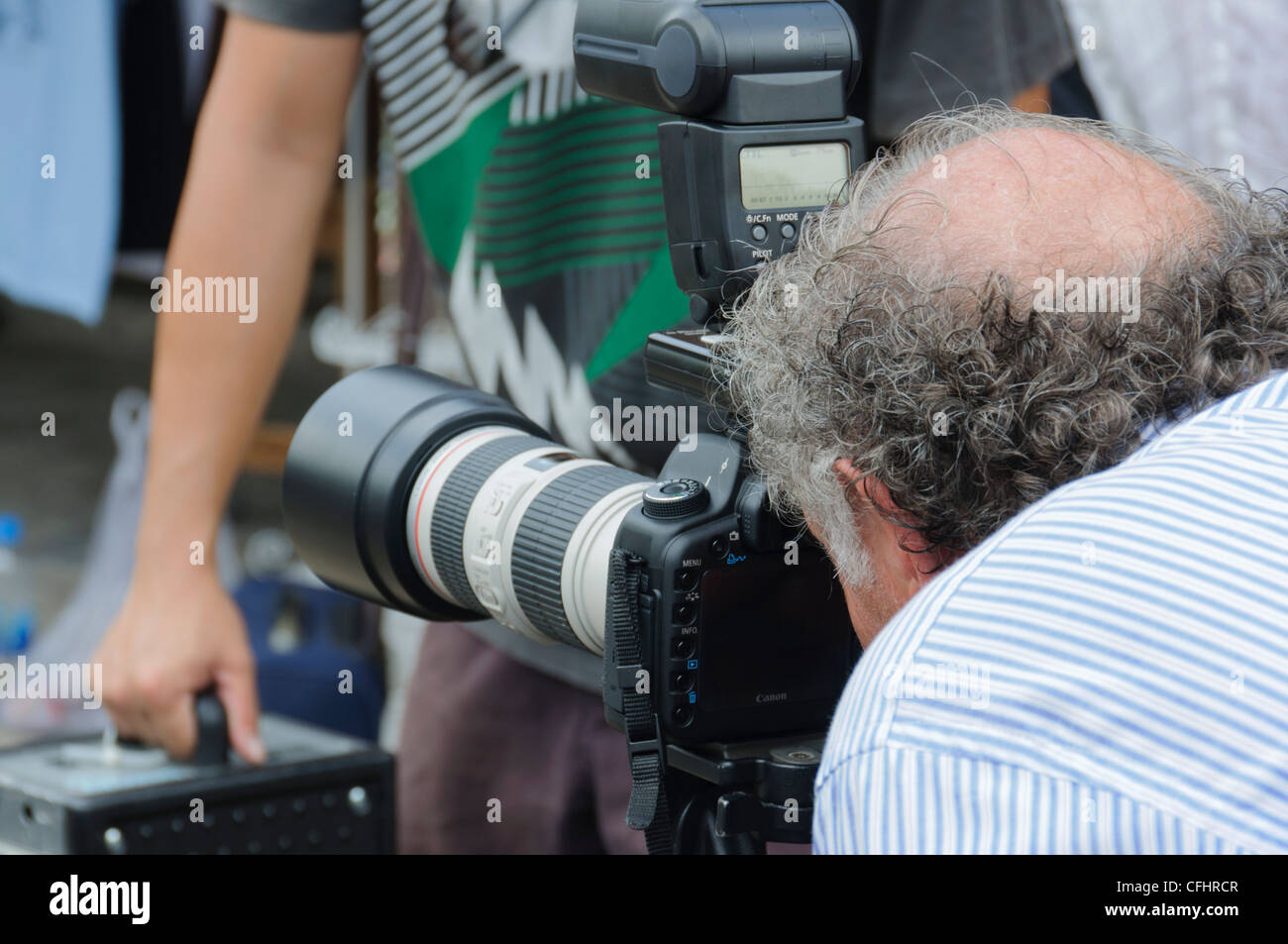 Back of a professional male Photographer with bald patch and grey hair ...
