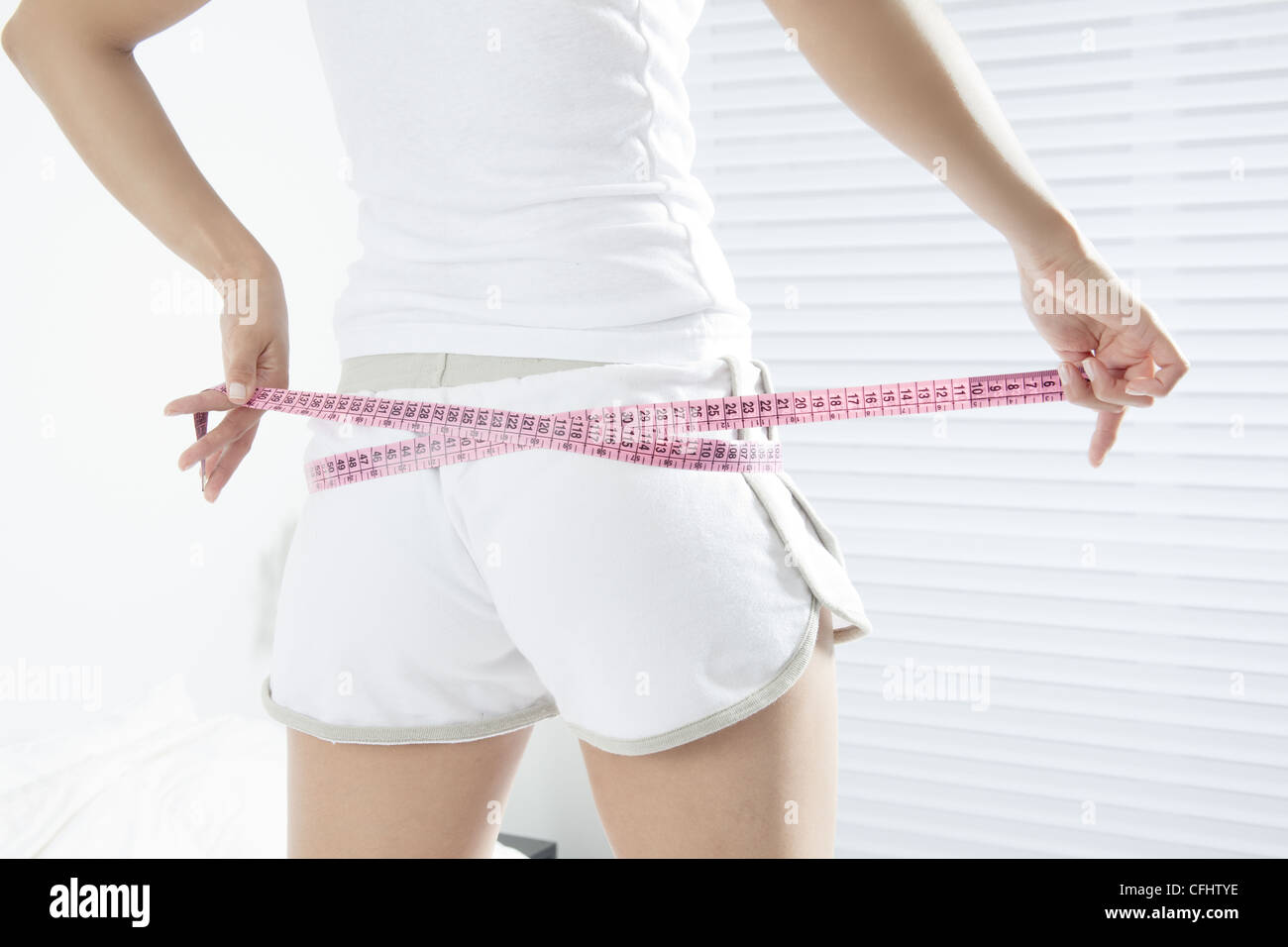 Young woman measuring hip with tape Stock Photo - Alamy