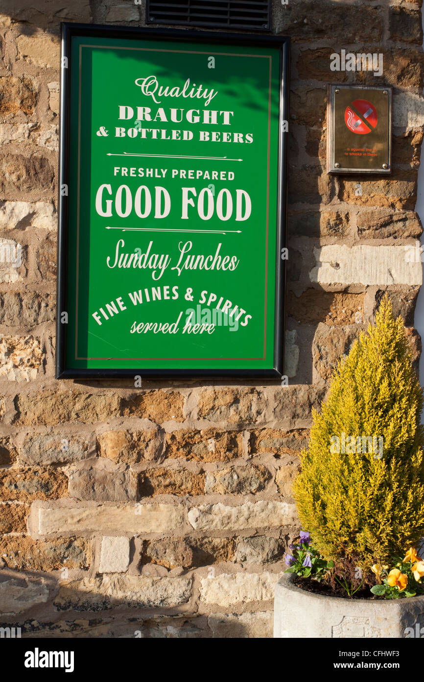 Sign outside an English country pub advertising quality draught beer ...