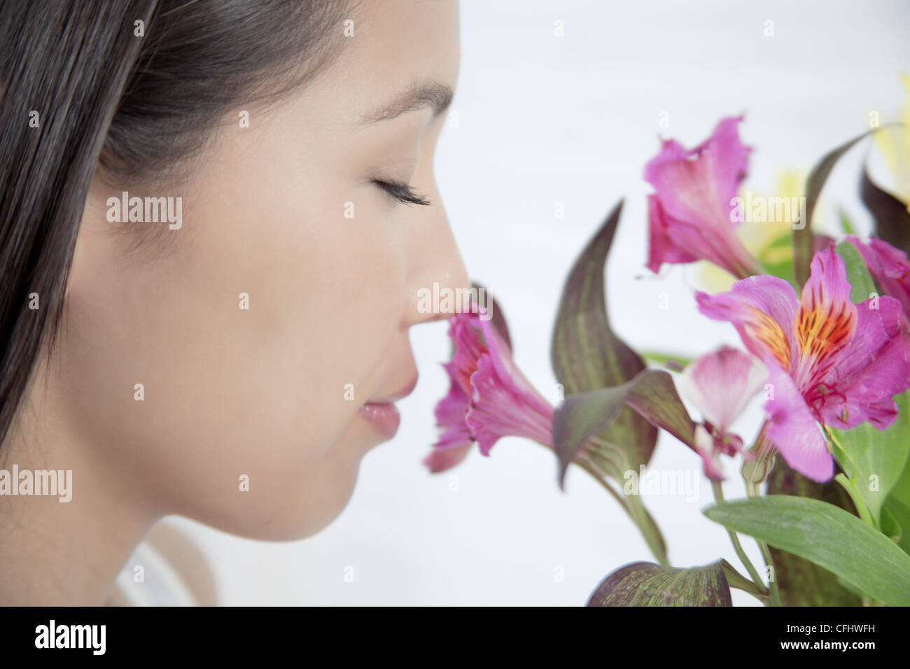 Young woman smelling flowers Stock Photo - Alamy