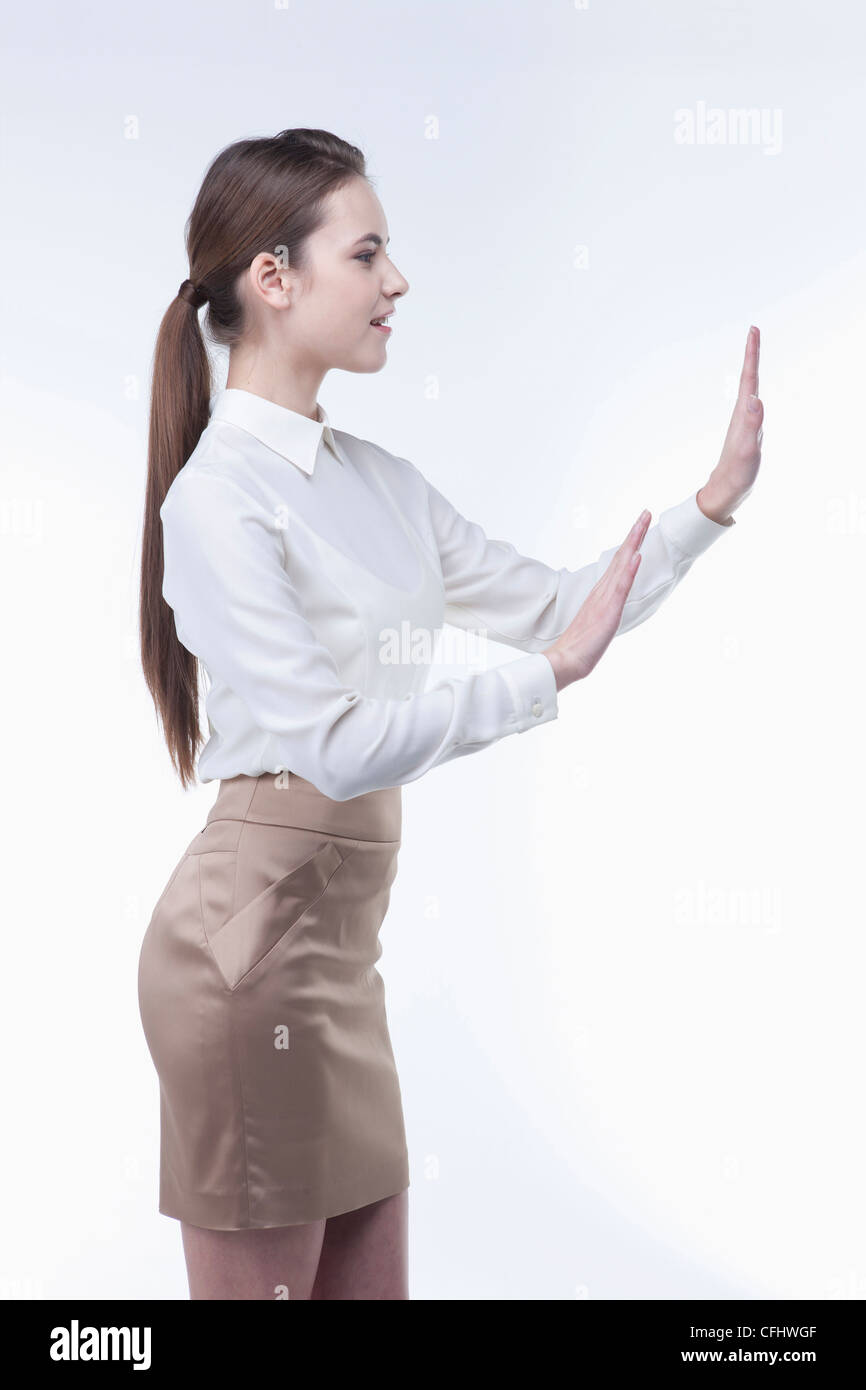 The standing woman with her touching palms from the side Stock Photo ...