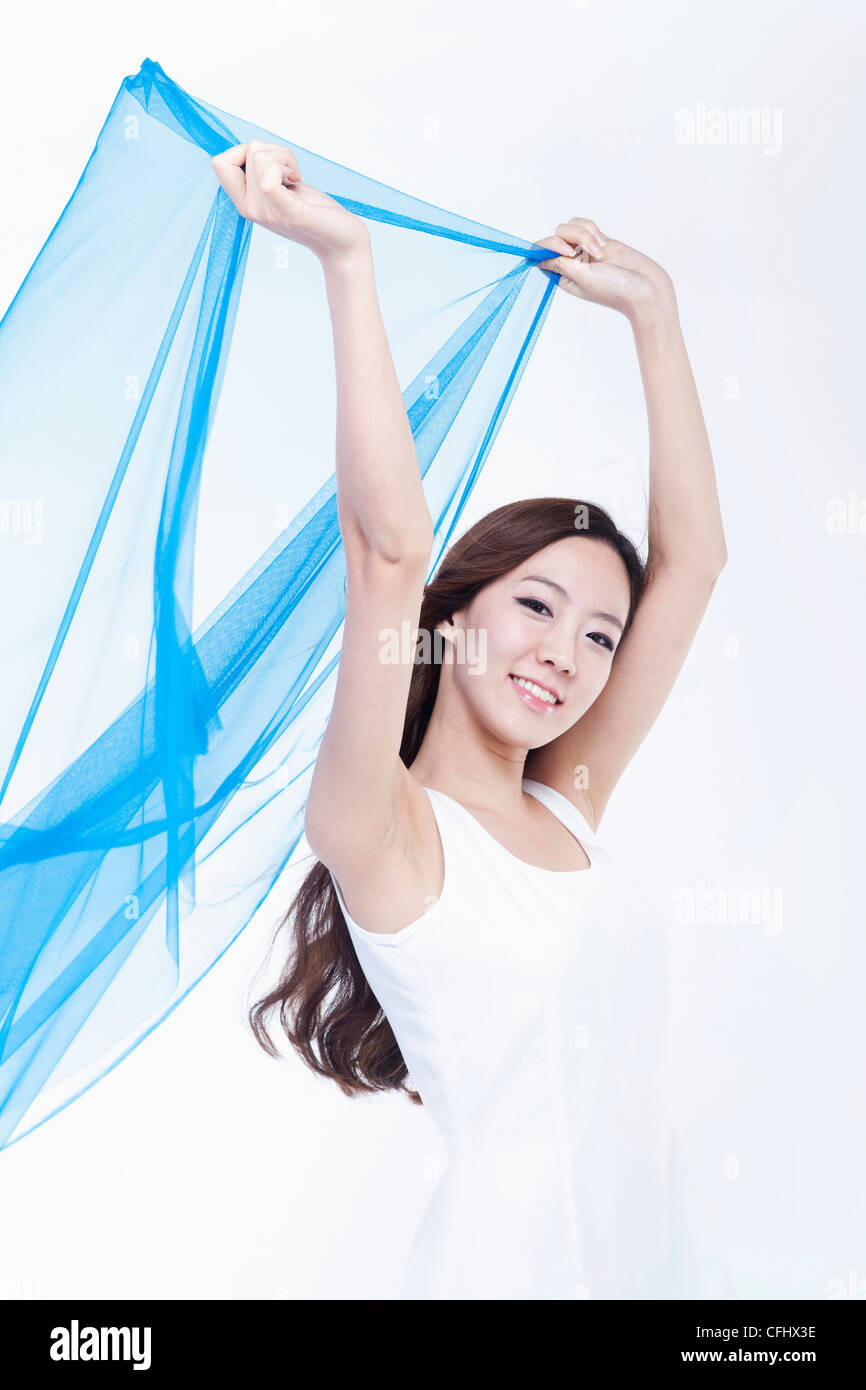 The smiling woman with the windblown blue cloth Stock Photo - Alamy