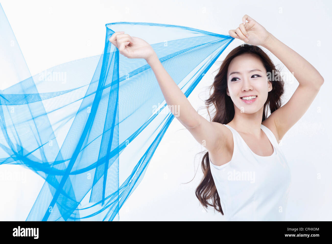 The smiling woman with the windblown blue cloth Stock Photo - Alamy
