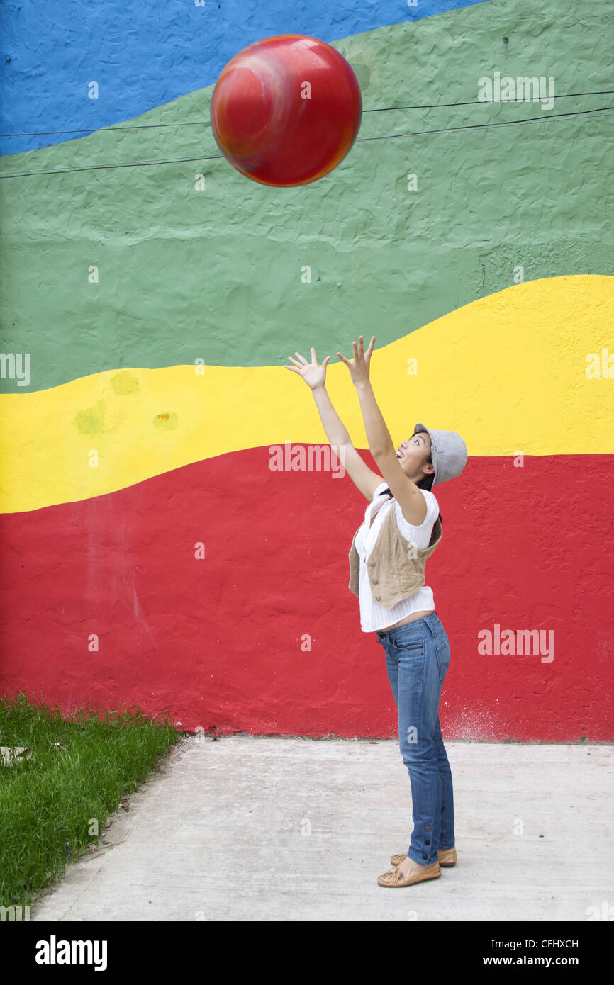 Young woman throwing a big ball Stock Photo - Alamy